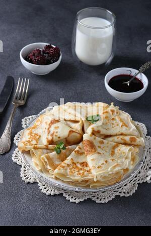 Thin pancakes made from wheat flour, eggs and milk on light blue ...