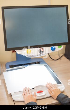 A visually impaired woman uses special reading equipment Stock Photo ...