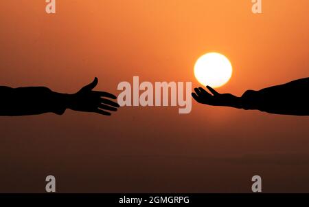 Human hand holding the Sun and giving it To another person. Helping ...