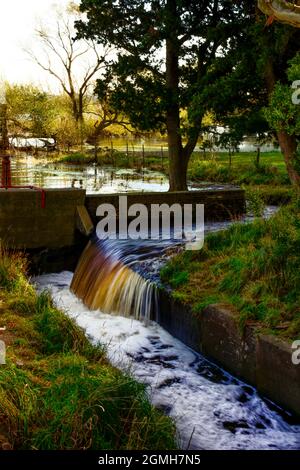 A vertical shot of a water canal flowing between buildings in Navigli ...