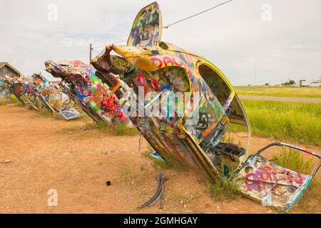 painted Volkswagen Beetles half buried at an angle at Slug Bug Ranch ...