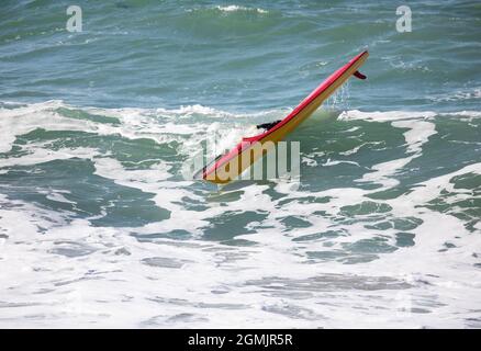 Swimmers and canoe in the surf Stock Photo - Alamy