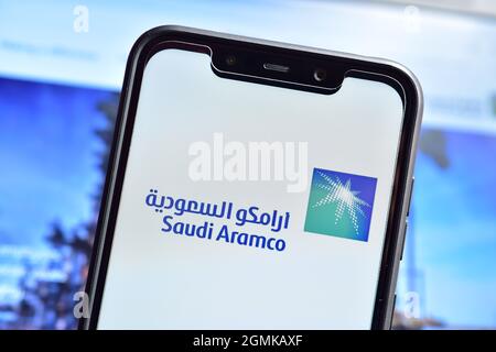 Saudi Aramco company logo on a white screen and finger pointing at it ...