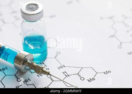 small jars with injection and syringe for injection on blue background ...