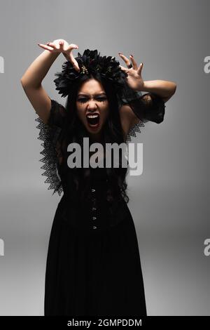 growling asian woman in vampire halloween costume holding spooky skull ...