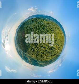 Little planet with dark mountain hills covered with green mixed pine ...