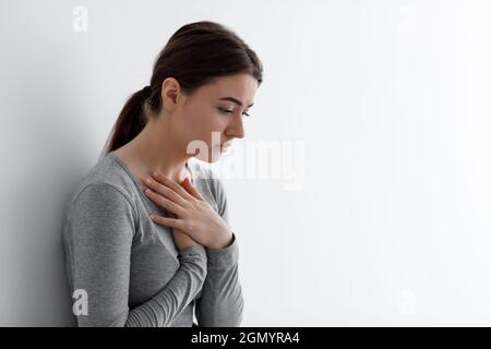 Indifferent caucasian young female suffering from depression, touching ...