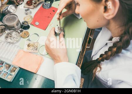 Woman watchmaker working diligently on repairing a watch Stock Photo ...