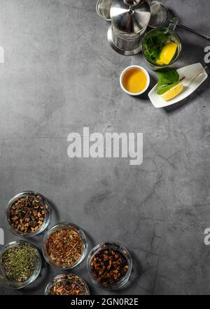 Creative layout made with cup of herbal tea with various herbs on dark ...