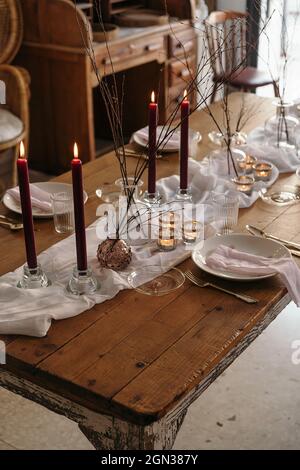 Wooden plates with burning candles on end table near grey wall Stock ...
