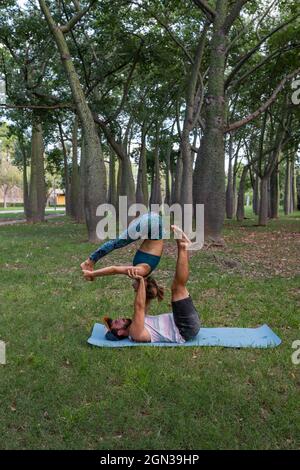 Full length of concentrate couple in activewear doing asana while ...