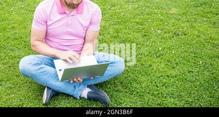 cropped freelance man post blog online sit on grass, copy space, agile ...