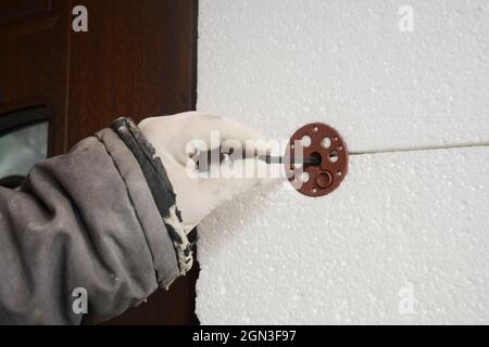 Builder contractor installing rigid styrofoam insulation board with ...