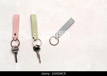 Keys with stylish keychains on light background Stock Photo - Alamy