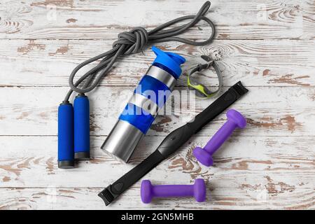 Sport top, fitness tracker, chest belt and sport equipment on light ...