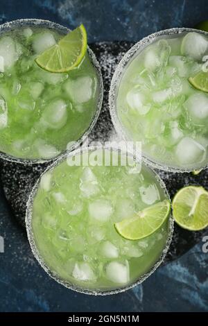 Slate plate with glasses of tasty daiquiri cocktail on color background ...