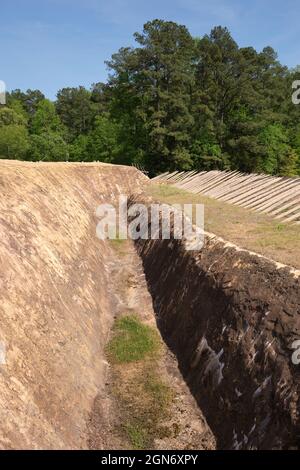 Trench, ditch with sharpened inclined log fraise defense. At the ...