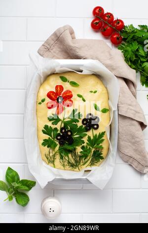 Raw focaccia decorated with vegetables on dark table Stock Photo - Alamy