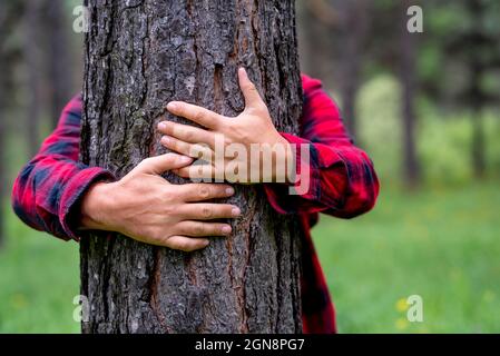 Mature man hugging tree trunk in forest Stock Photo - Alamy