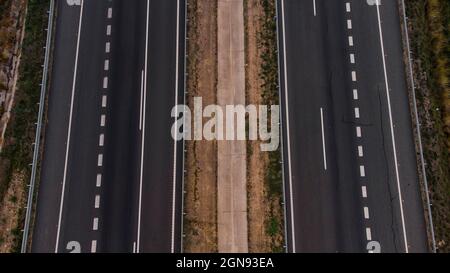 An aerial view of a multiple lane highway road with green vegetation ...