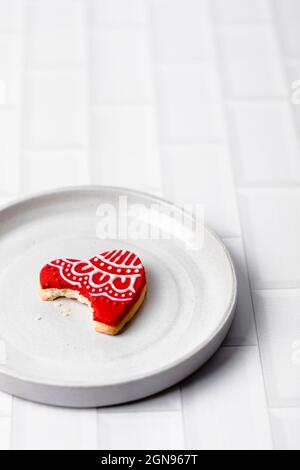 Heart shaped cookies on the pink plate on white wooden background. Flat ...