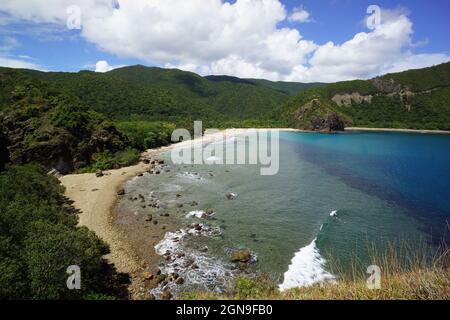 Breathtaking view of the seaside land with hills and dense vegetation ...