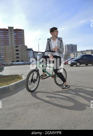 Kovrov, Russia. 9 April 2017. Teen on BMX bike performs a trick near the shopping center Rus ...