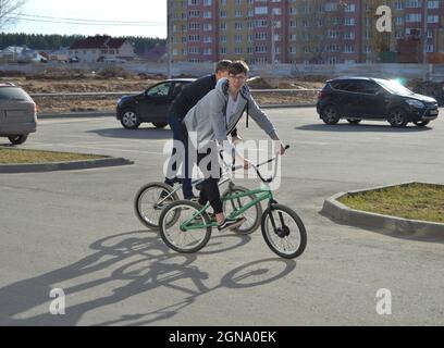 Kovrov, Russia. 9 April 2017. Teens who ride on BMX bikes resting and looks at ride friends on ...