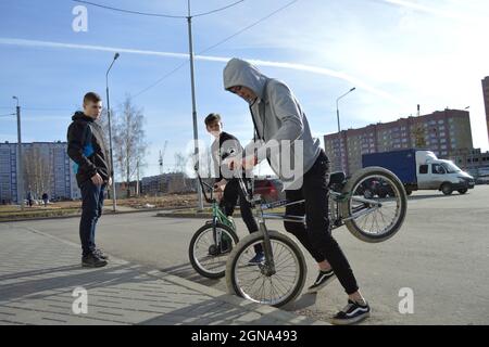 Kovrov, Russia. 9 April 2017. Teens who ride on BMX bikes resting and looks at ride friends on ...