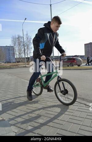 Kovrov, Russia. 9 April 2017. Teen on BMX bike performs a trick near the shopping center Rus ...