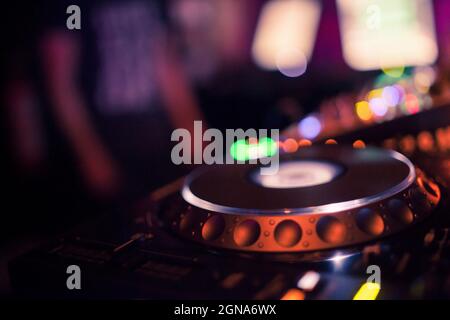 DJ playing music during a party in a club with colorful lights on Stock ...