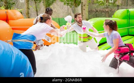 Game of funny friends in soap suds on an inflatable trampoline Stock ...