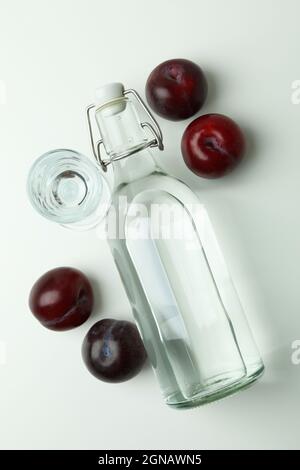 Bottle and shot of plum vodka and ingredients on white background Stock ...