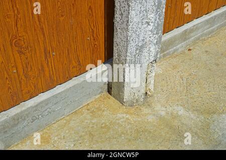 The hexagonal concrete column is concreted in the sidewalk near a metal ...