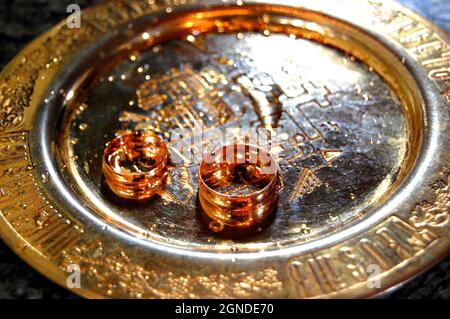 Wedding rings on golden platter in church Stock Photo - Alamy