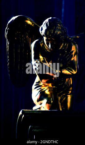 figure of an angel sitting on his knees Stock Photo - Alamy