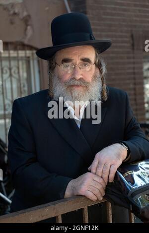 A posed portrait of an orthodox Jewish man dressed for Purim in a ...