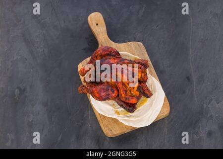 Shawai chicken arranged on a wooden base with kuboos and side dishes ...