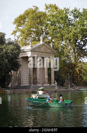 Rome. Italy. People in boats rowing around the Ionic Temple of ...