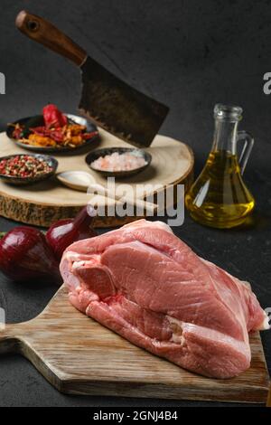 Raw slice of beef steamship round with cooking ingredients on black ...