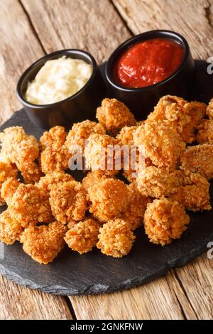 Tasty fried chicken popcorn pieces topped with yellow cheese sauce ...