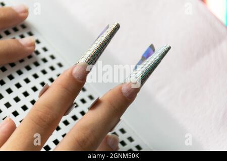 Professional woman applying nail builder gel. nail extension sticker ...