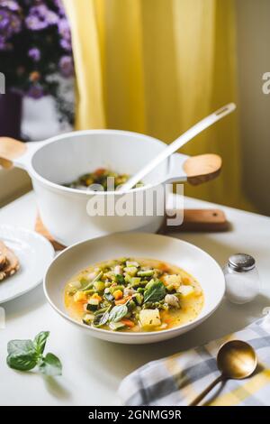 Minestrone in a plate with a spoon, close up Stock Photo - Alamy