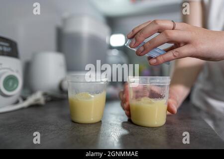 Hands of woman hold plastic containers with different frozen foodstuffs ...
