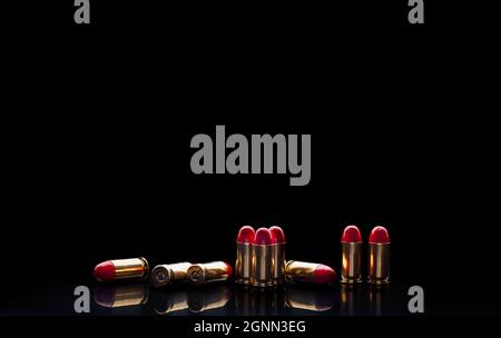 Pistol cartridges with red silicone coating. Bullets for a pistol on a ...