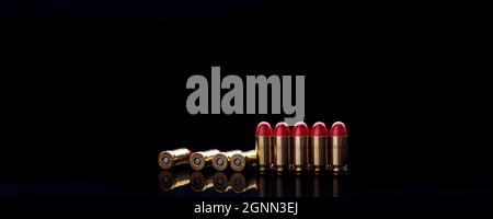 Pistol cartridges with red silicone coating. Bullets for a pistol on a ...