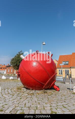 Red maritime navigation buoy floating in turquoise ocean waters near a ...