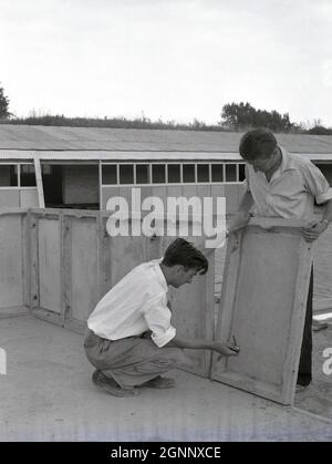 1960s, historical, constructing a prefab garage on an industrial ...