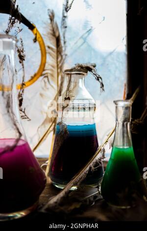 Magic potions in bottles near old rustic window with backlight ...