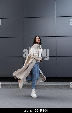 Woman in a grey outfit running in urban setting Stock Photo - Alamy
